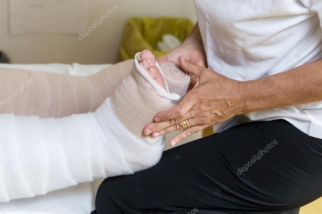 Woman bandaging patient's legs — Stock Photo © vpardi #113158490