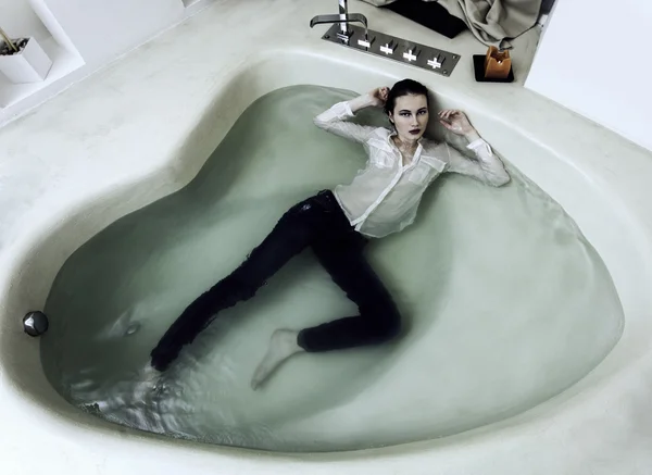 Woman lying in a bath tub with her clothes on Stock Photo by ...