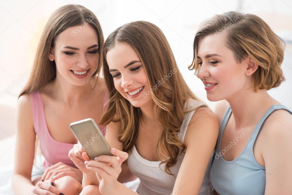 Positive girls using smart phone Stock Photo by ©yacobchuk1 106701354