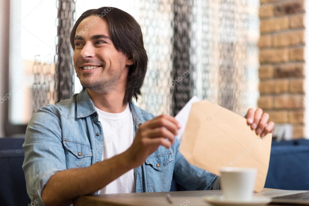 Cheerful man opening a letter Stock Photo by ©yacobchuk1 119731864