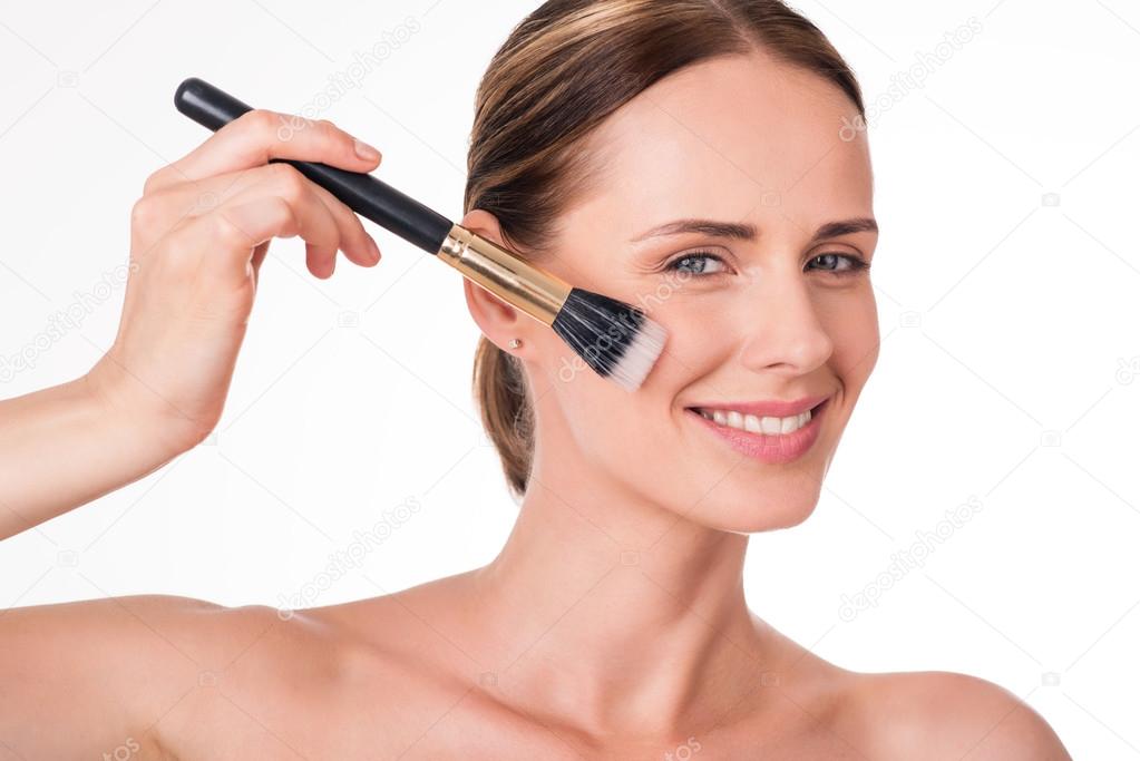 Young woman using makeup brush Stock Photo by ©yacobchuk1 121379198