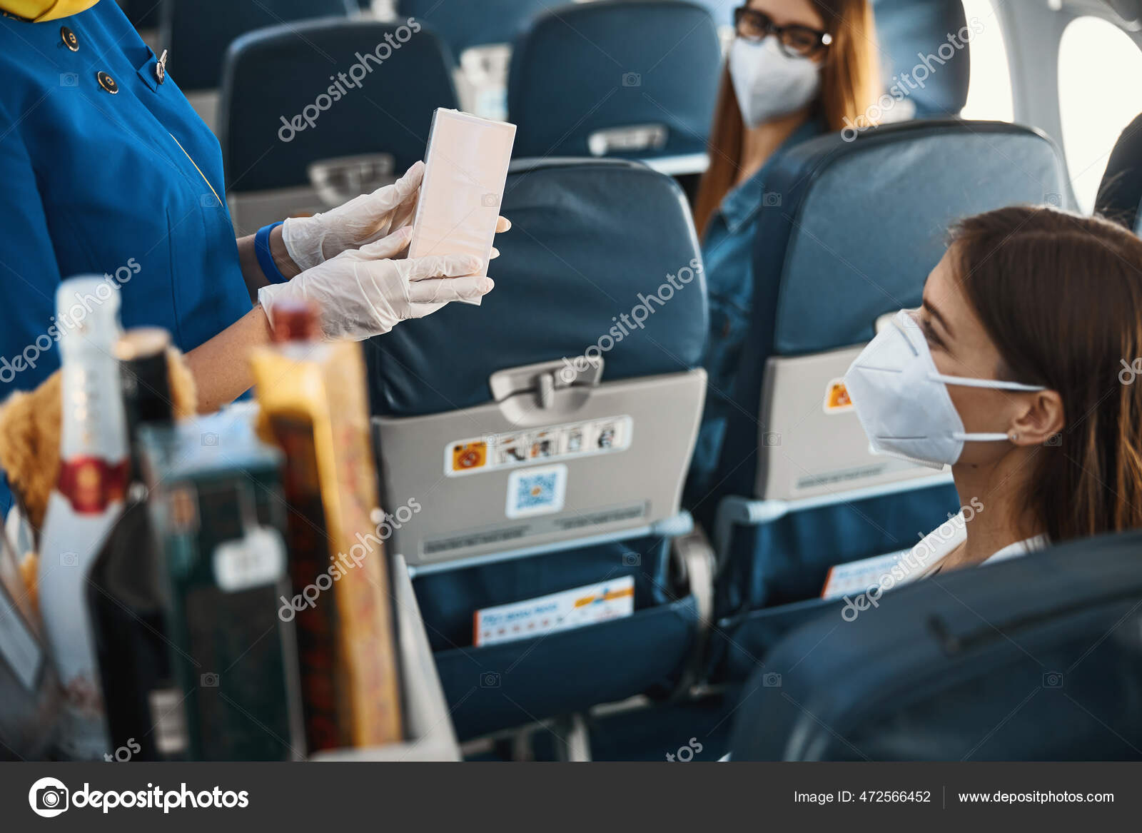 Female airline steward presenting box of cookies to woman Stock Photo ...