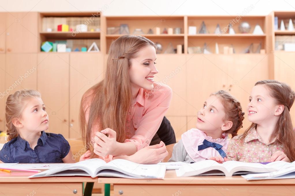 Young teacher explaining material to pupils — Stock Photo © yacobchuk1 ...