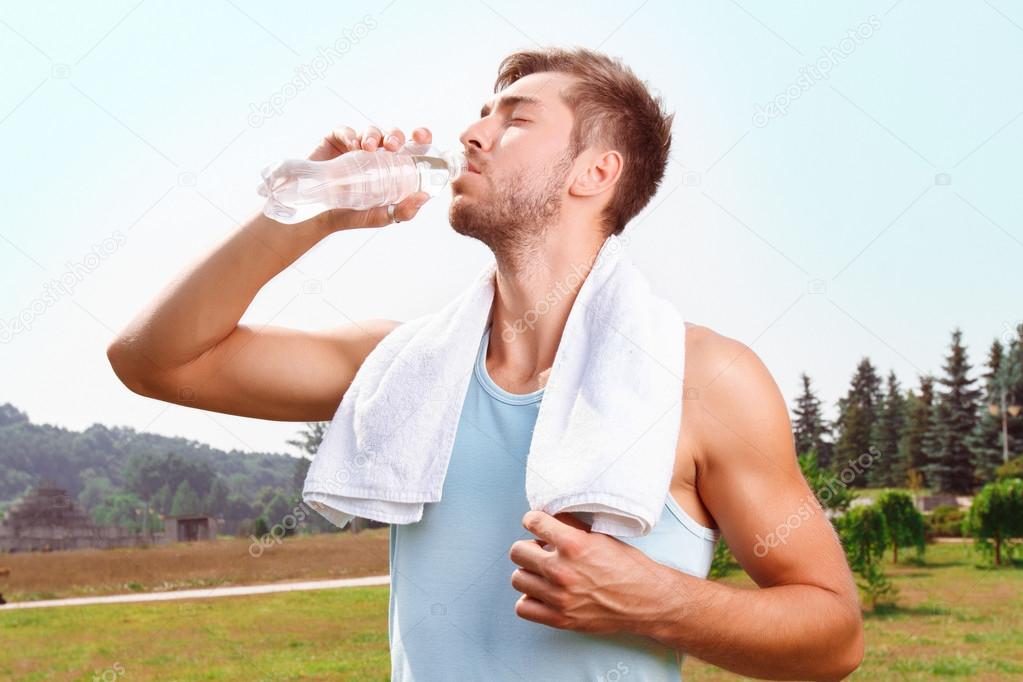Handsome guy drinking water — Stock Photo © yacobchuk1 #78792392