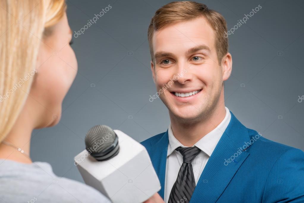Smiling newsman taking an interview. — Stock Photo © yacobchuk1 #93805442