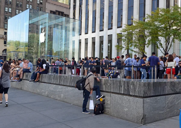 Customers wait on long lines outside the Apple Store in New York ...