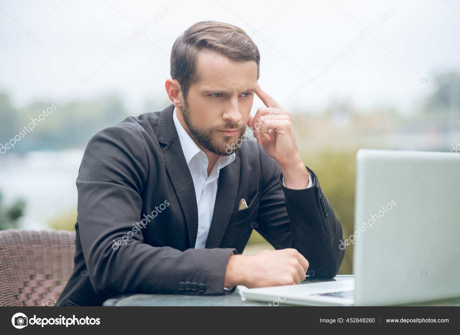 Attractive successful man seriously looking at laptop screen Stock ...