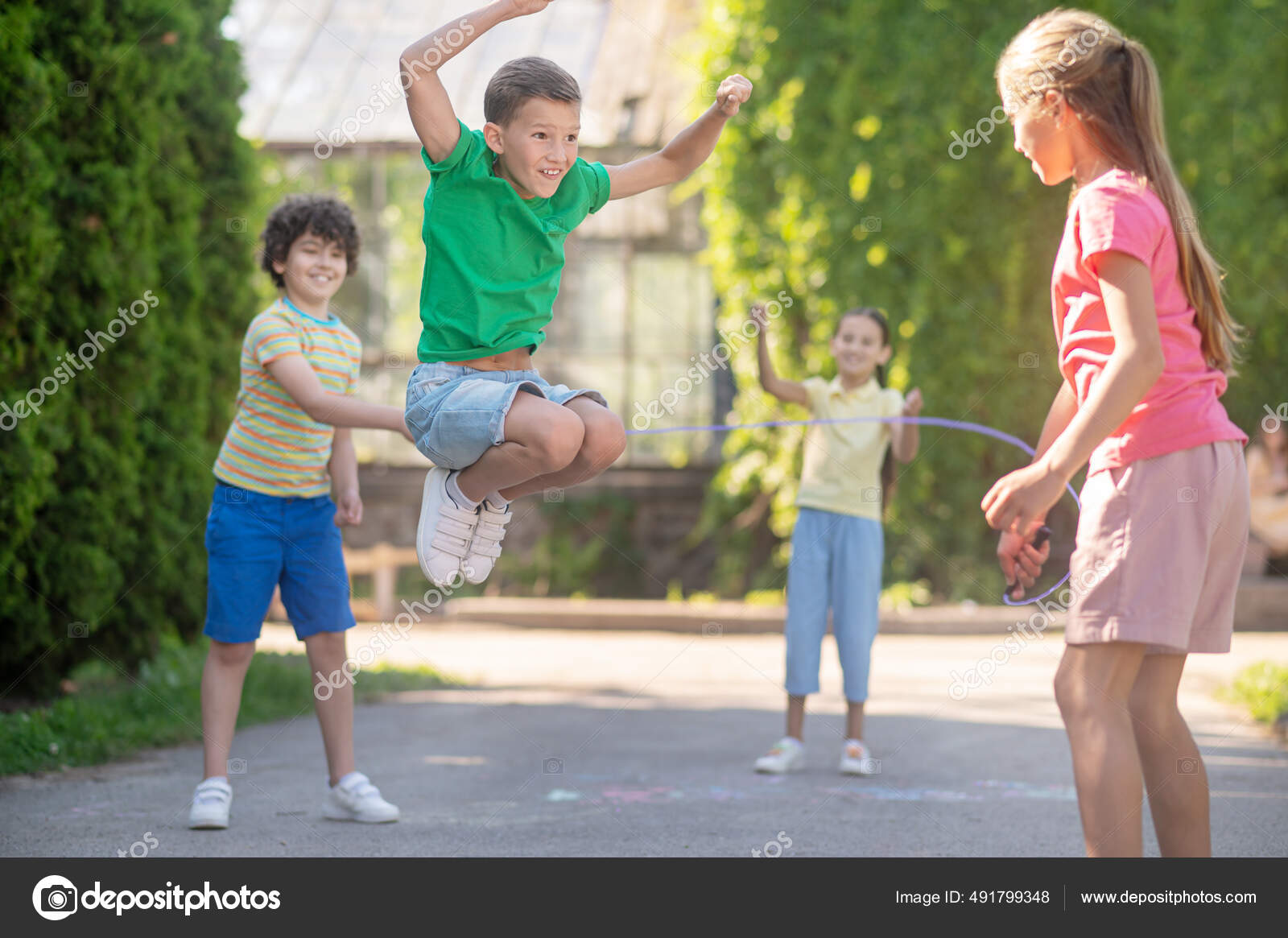 Jumping boy and friends with skipping rope — Stock Photo © Dmyrto_Z ...