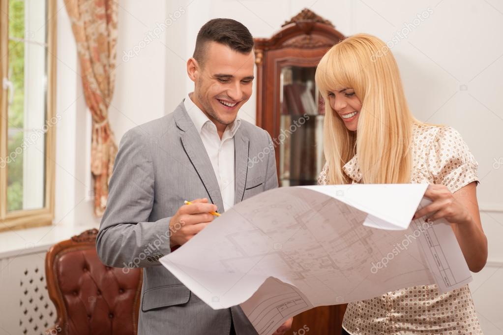 Two young attractive architects discussing design project holdin Stock ...