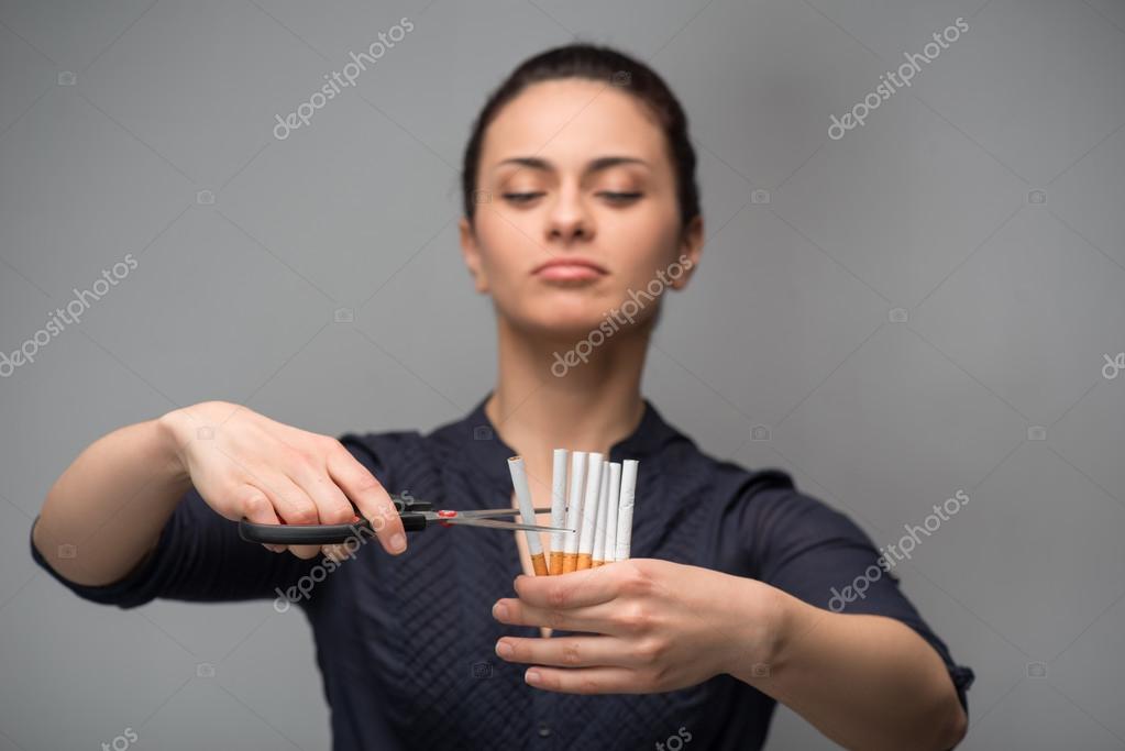 Woman cut cigarettes with scissors Stock Photo by ©Dmyrto_Z 61492401
