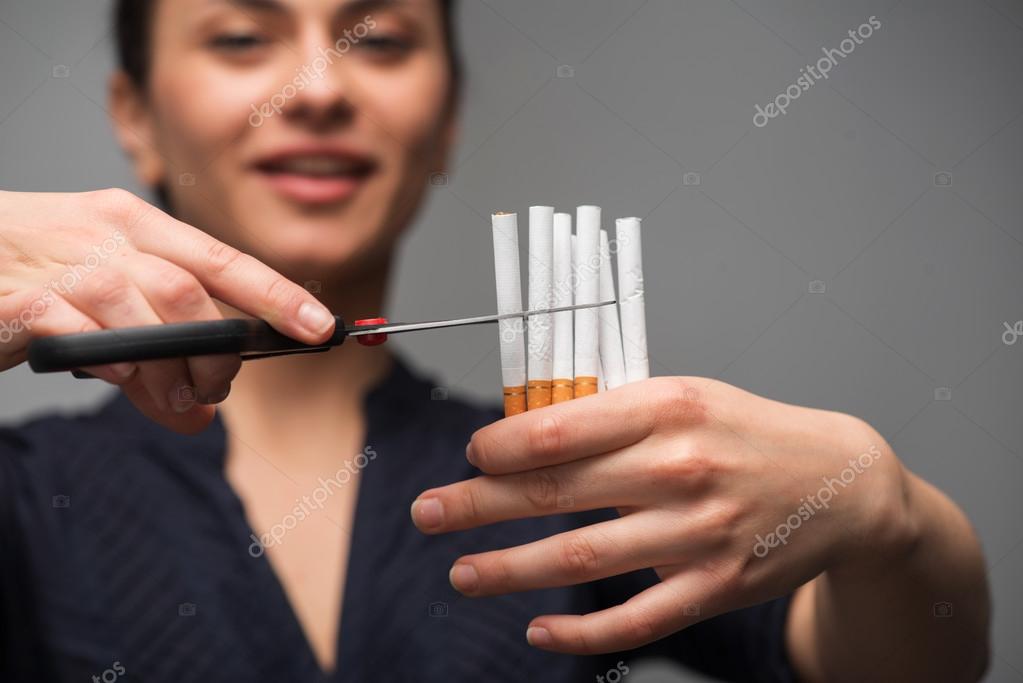 Woman cut cigarettes with scissors Stock Photo by ©Dmyrto_Z 61492463