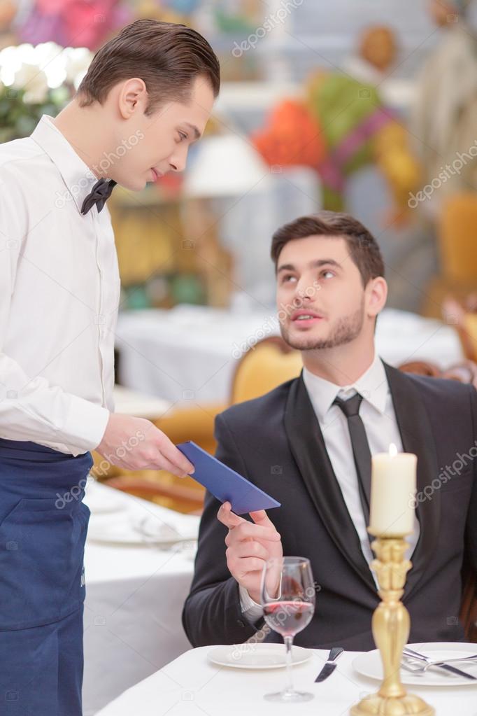 Waiter giving a bill to his customer Stock Photo by ©Dmyrto_Z 66960231