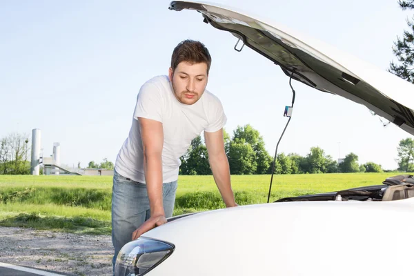 Man leaning on car with opened bonnet - Stock Image - Everypixel