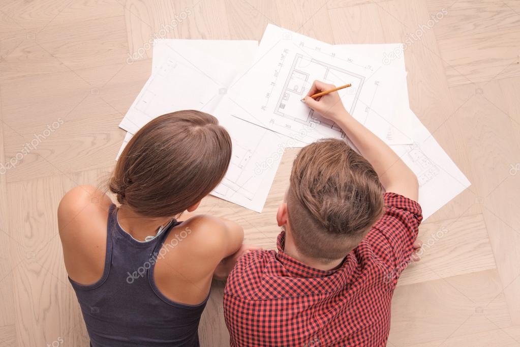 Pleasant couple drawing plan Stock Photo by ©Dmyrto_Z 79971264