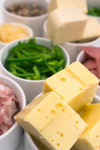 Pizza ingredients in separate bowls - Cheese, bacon, chopped bell ...