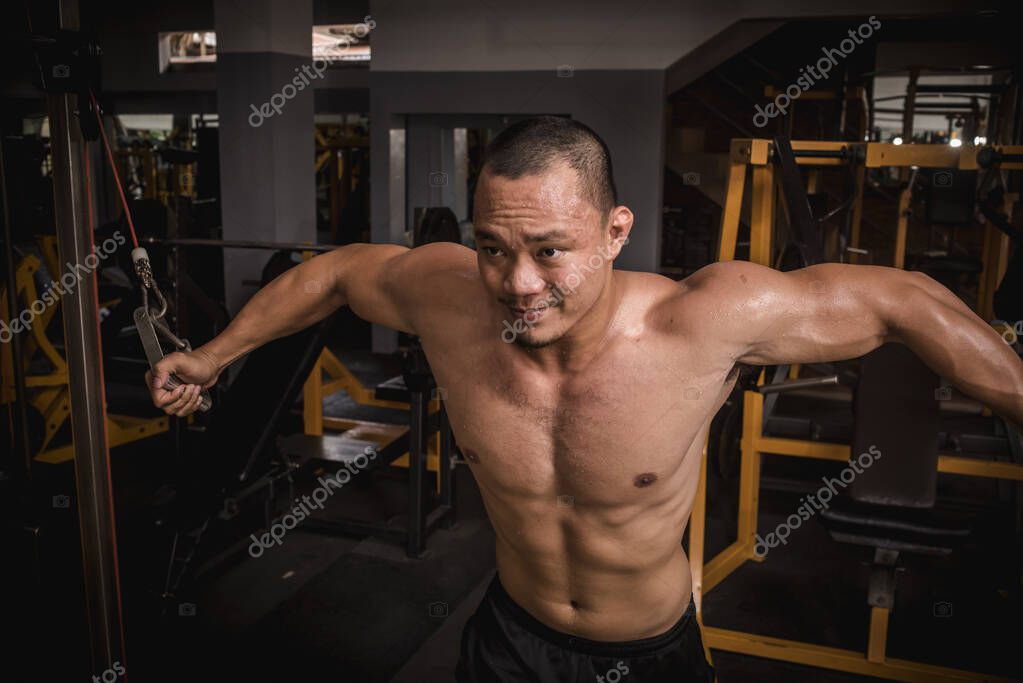 Un atleta filipino serio y decidido hace cruces de cables. Ejercicio de ...