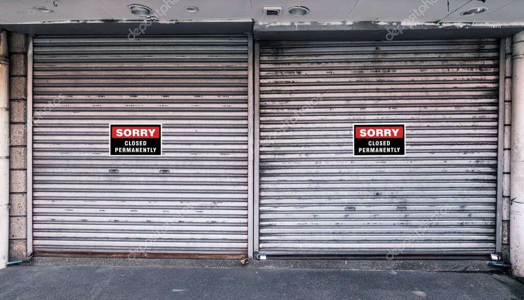 Dos puertas enrollables metálicas corrugadas cerradas con letreros ...