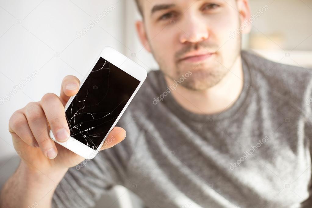 Sad man showing crashed mobile phone with touch screen Stock Photo by ...