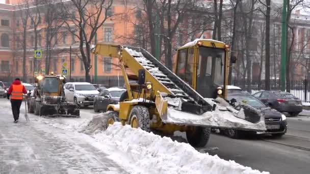 Tractor and snow plow remove snowy road after snowfall in St ...