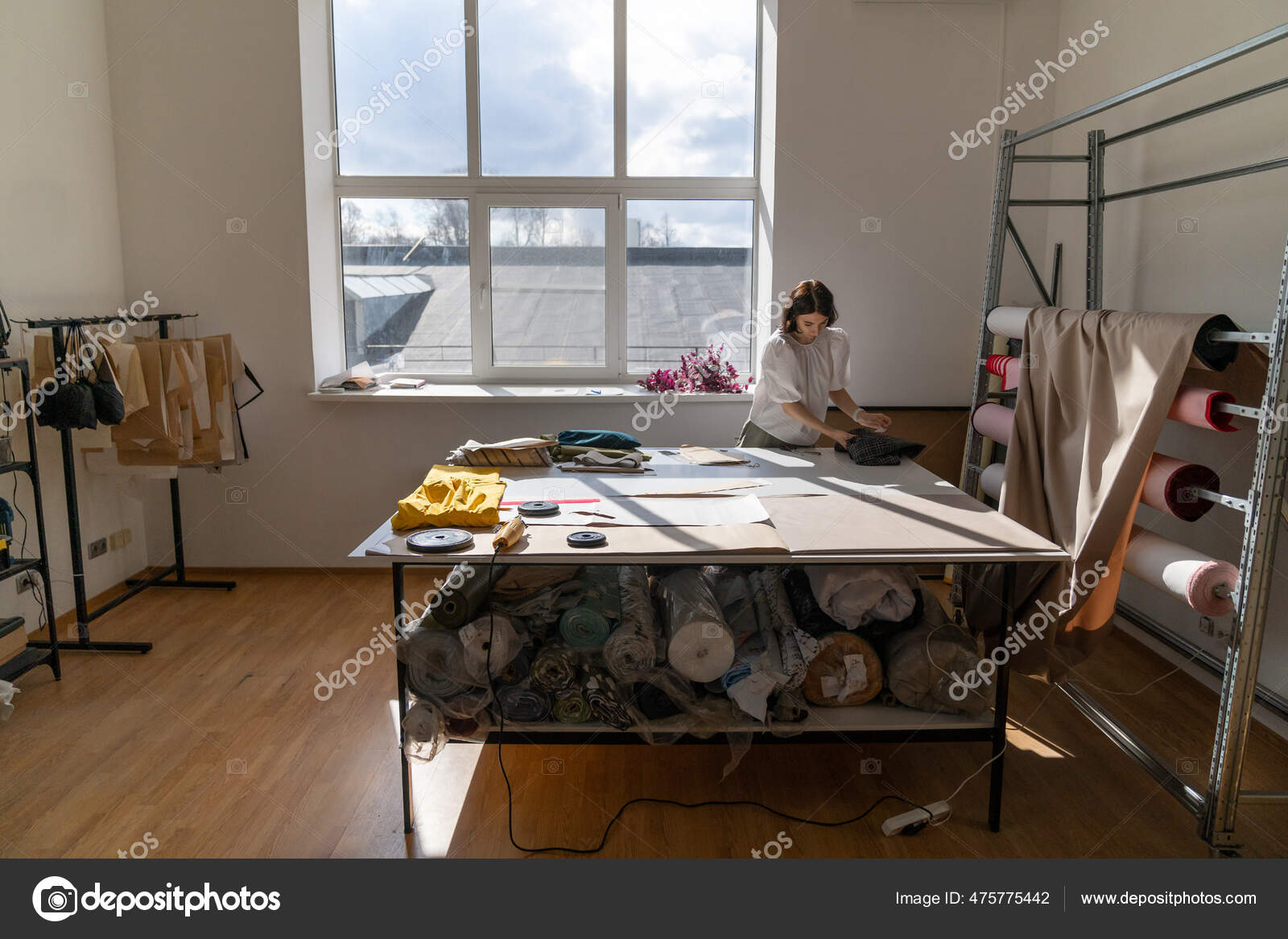 Female tailor work with fabric in studio. Young clothes designer ...