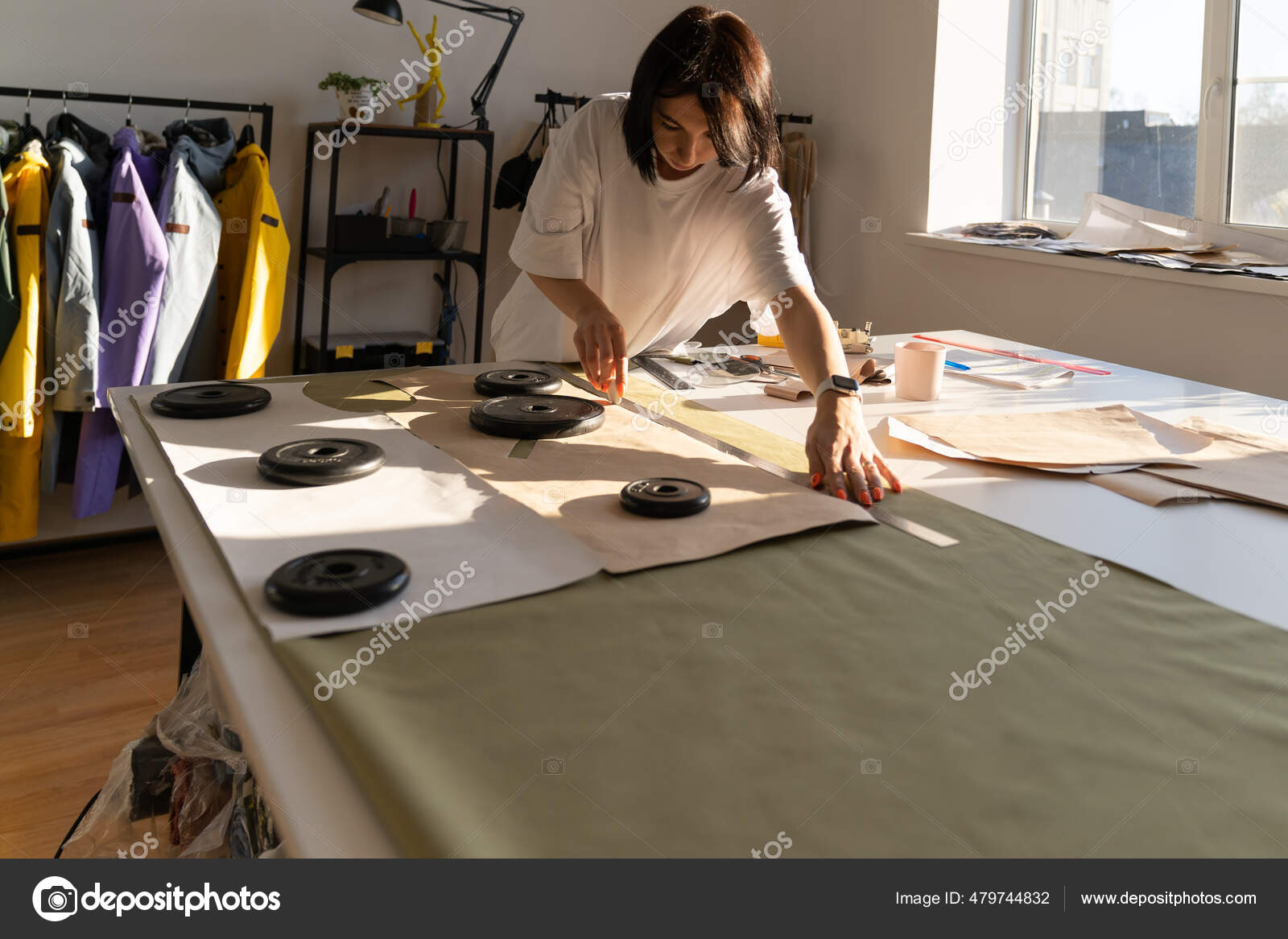 Seamstress draft paper patterns on textile with chalk and ruler ...