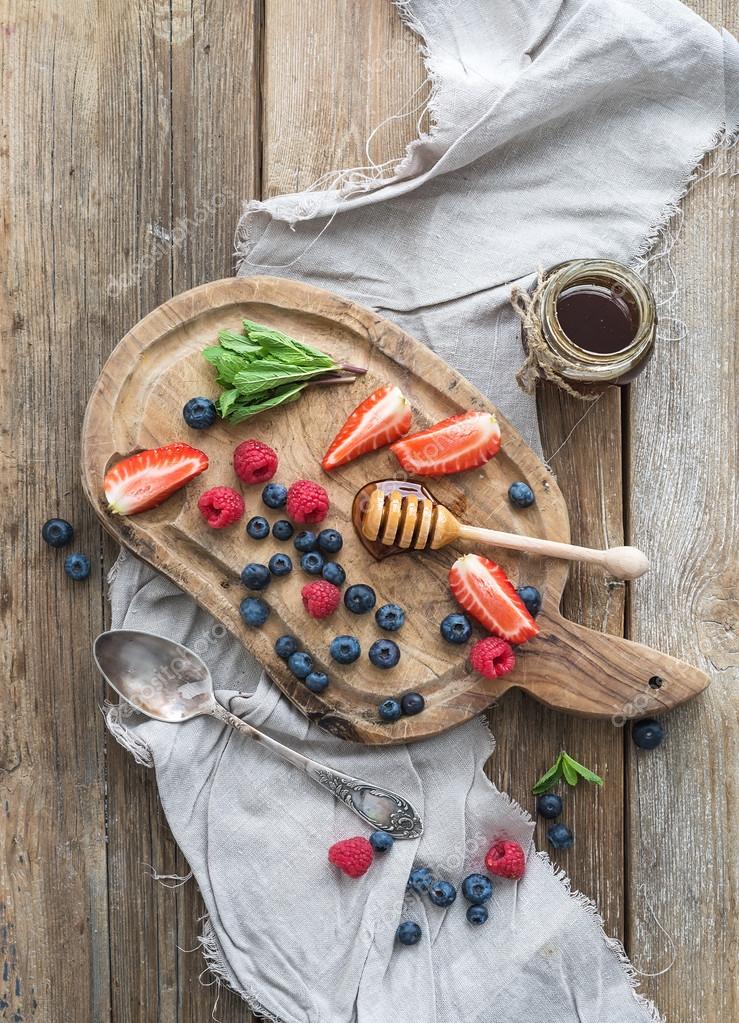 Arándanos, frambuesas, fresas, miel y menta fresca onver tabla de ...