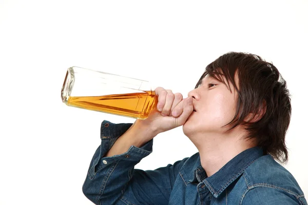 Young Japanese man drinking straight from a bottle Stock Photo by ...