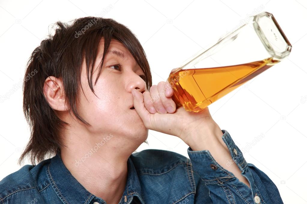 Young Japanese man drinking straight from a bottle — Stock Photo ...