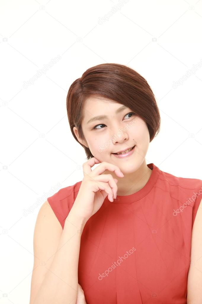 Young Japanese woman thinks about something — Stock Photo © deeblue ...