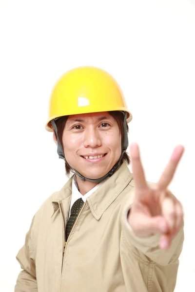 Young Japanese construction worker presenting and showing something ...