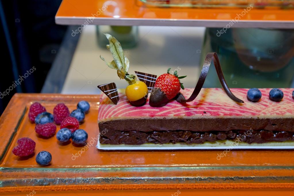 Dark chocolate cake with fresh fruit topping and around display — Stock ...