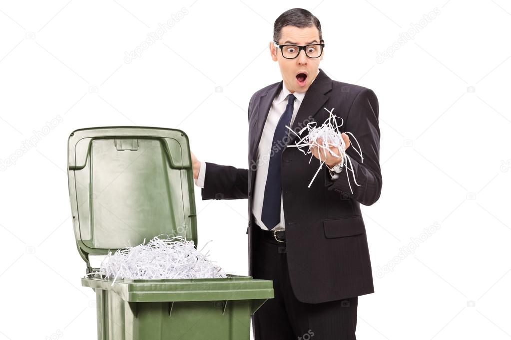 Shocked businessman looking into trash can Stock Photo by ...