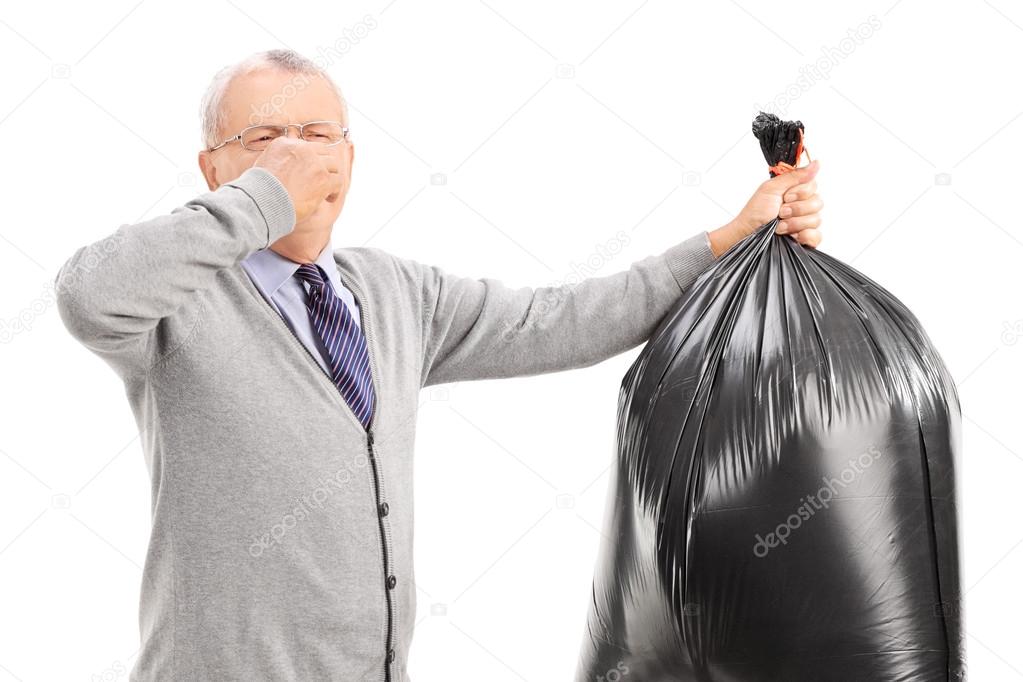Senior carrying stinky garbage bag — Stock Photo © ljsphotography #59506713