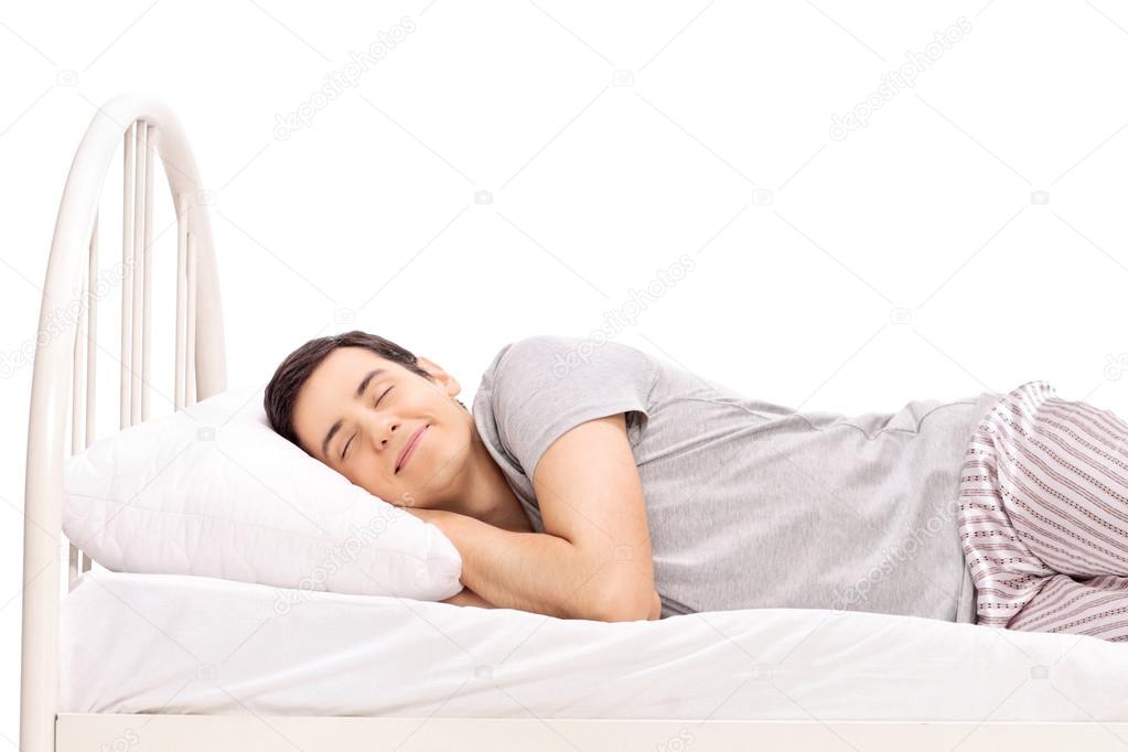 Happy young man sleeping in a bed — Stock Photo © ljsphotography #82322094