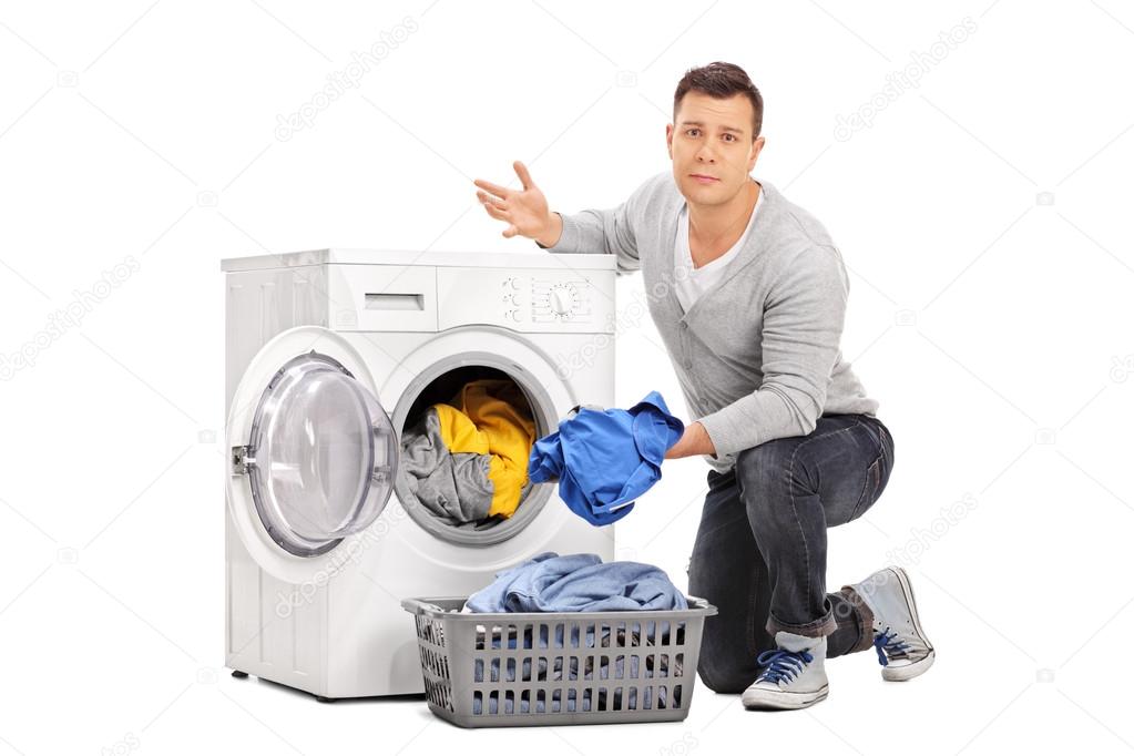Sad guy emptying a washing machine Stock Photo by ©ljsphotography 95586082