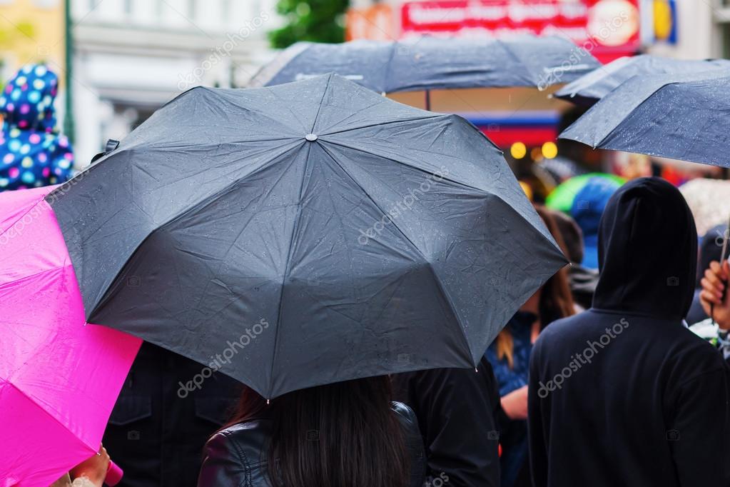 People Sharing An Umbrella