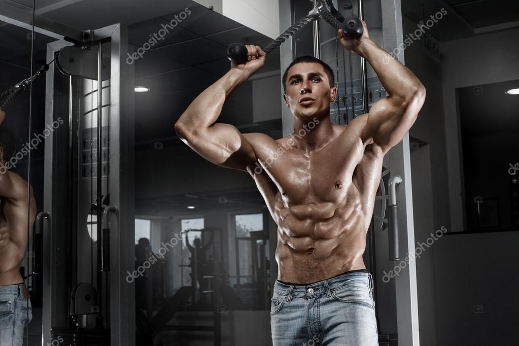 Hombre musculoso sexy haciendo ejercicio en el gimnasio, en forma ...