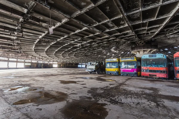 Abandoned bus depot with amazing construction circus and colored buses ...