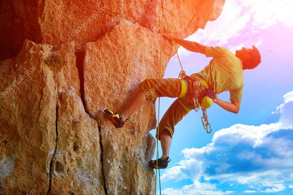 Rock climber climbing up a cliff — Stock Photo © matehavitaliy #76663327