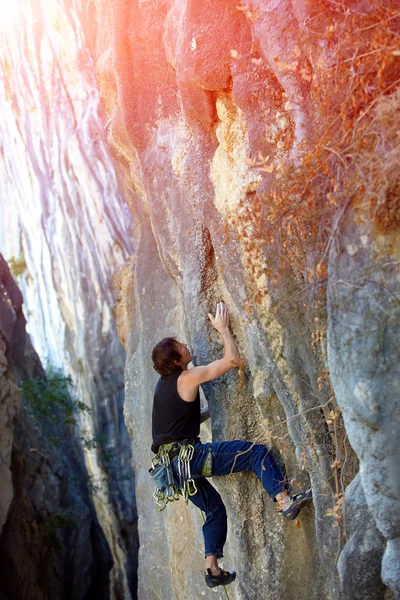 Rock climber climbing up a cliff - Stock Image - Everypixel