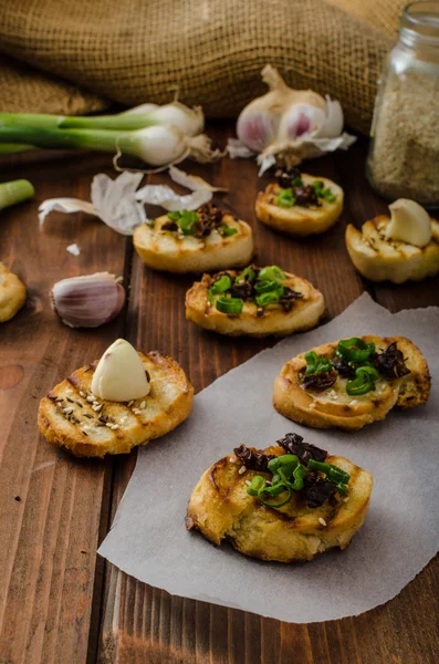Mini toasts with garlic and dried tomato Stock Photo by ©Peteer 73621451