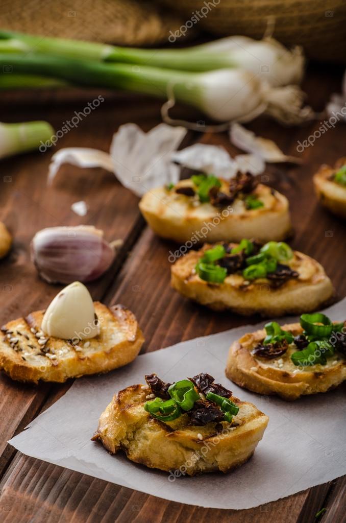 Mini toasts with garlic and dried tomato — Stock Photo © Peteer #73621555