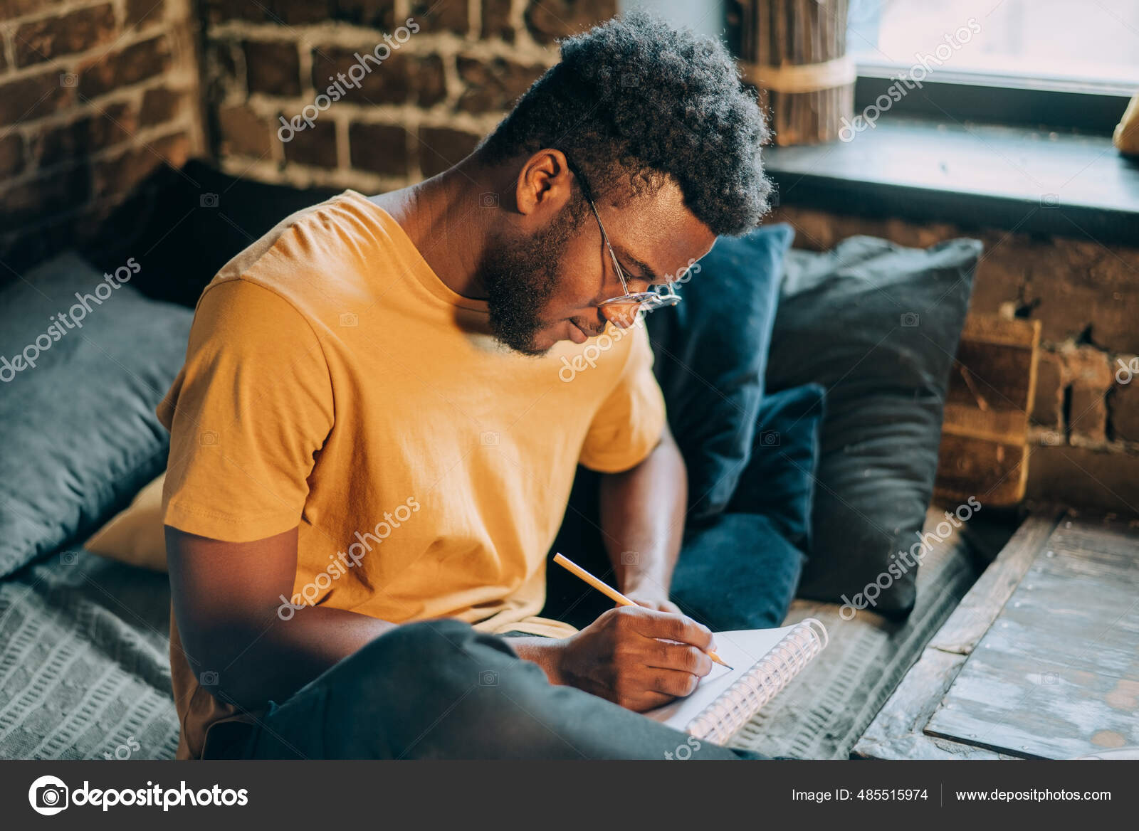 Young attractive black man with dark skin write down in the paper ...