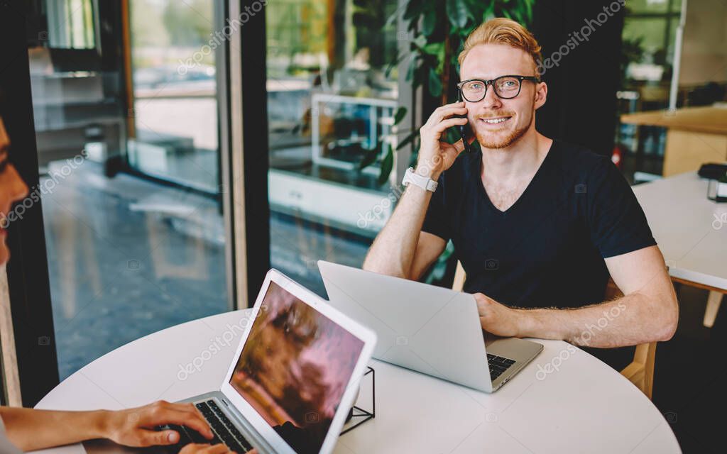 Retrato de desarrollador de software feliz haciendo conversación de teléfono celular para ...