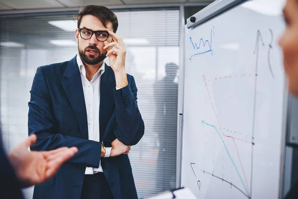 Proud ceo dressed in suit discussing financial graphic from flip chart ...