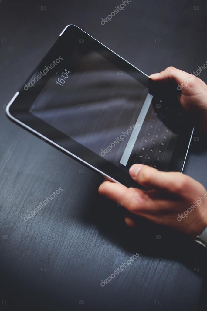 Las manos del hombre usando una tableta digital 2024