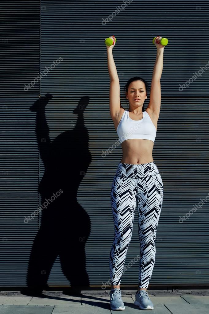 Woman during training with dumbles Stock Photo by ©GaudiLab 74408329