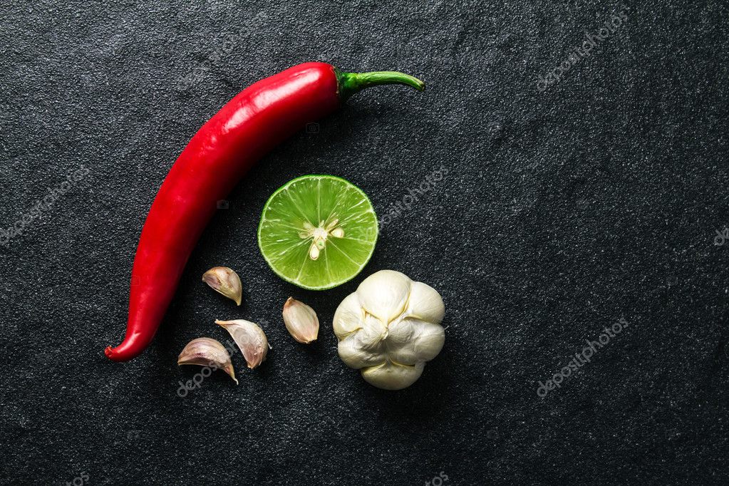 Red chili , garlic and lime lemon arrange on black stone — Stock Photo ...