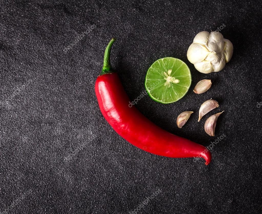 Red chili , garlic and lime lemon arrange on black stone backgro — Stock Photo © photorista ...