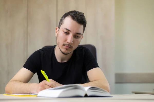 Young male student in the learning process with a pen and abstract ...